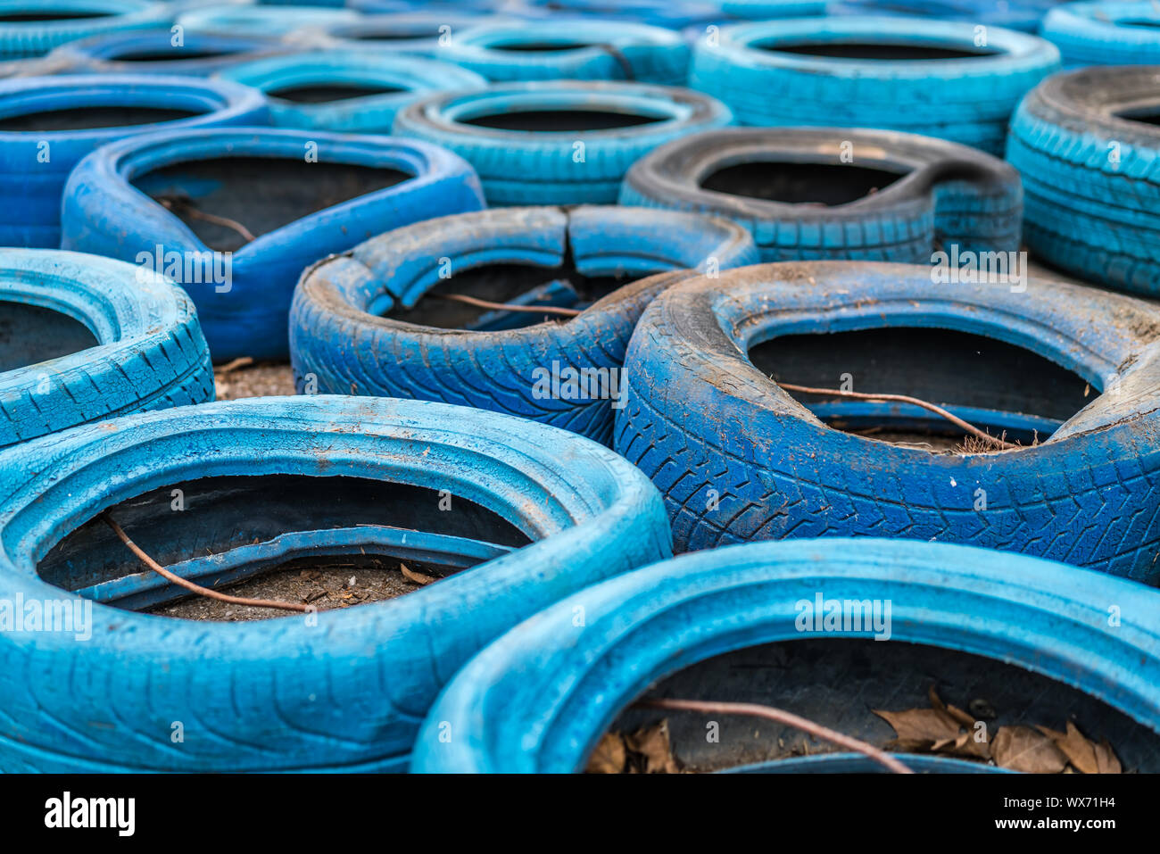 Blue disused tyres on the ground Stock Photo - Alamy