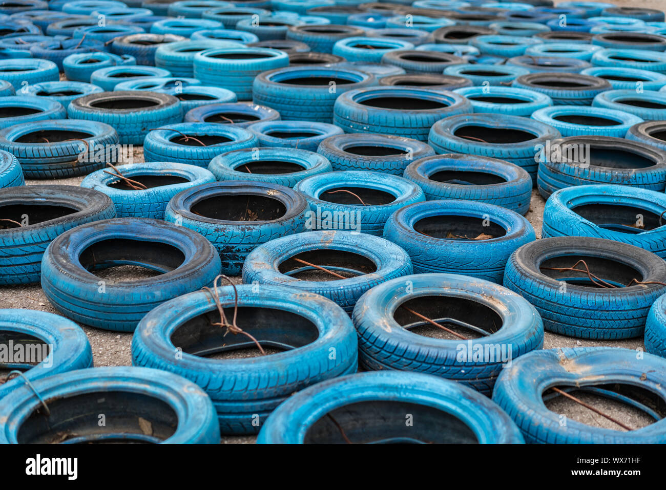 Blue disused tyres on the ground Stock Photo - Alamy