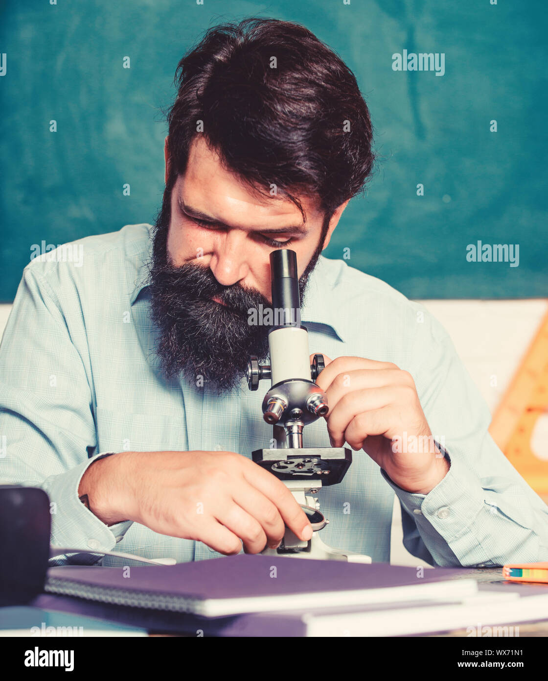 Set up microscope. Teacher sit desk with microscope. Man bearded ...