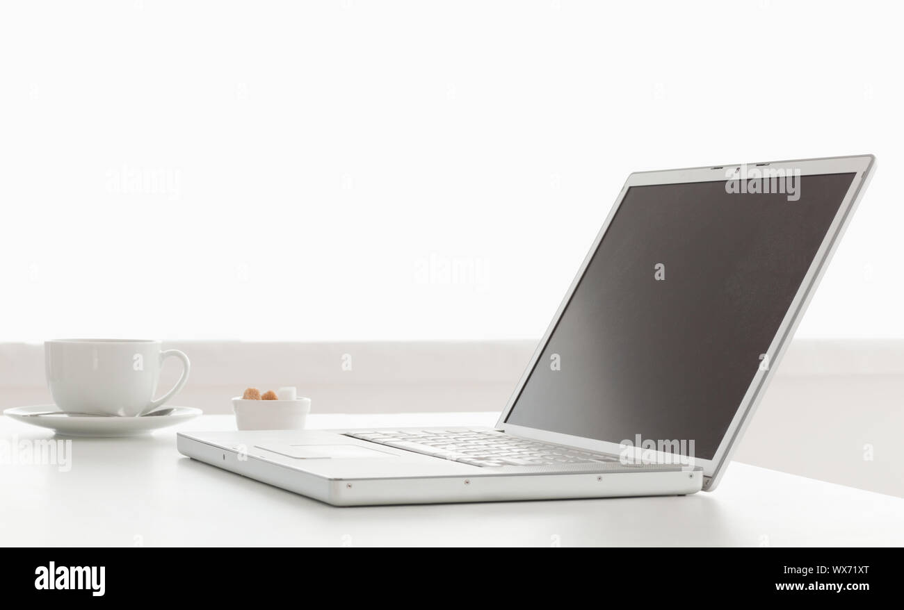 Modern and stylish laptop on a table in the kitchen Stock Photo - Alamy