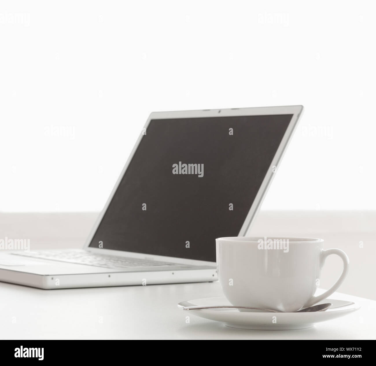 Modern laptop and cup of tea on a table in the kitchen Stock Photo - Alamy