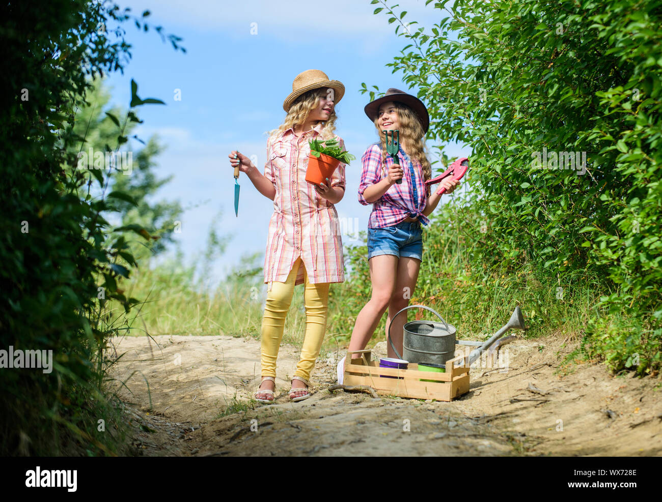 Adorable girls in hats going planting plants. Kids siblings having fun ...