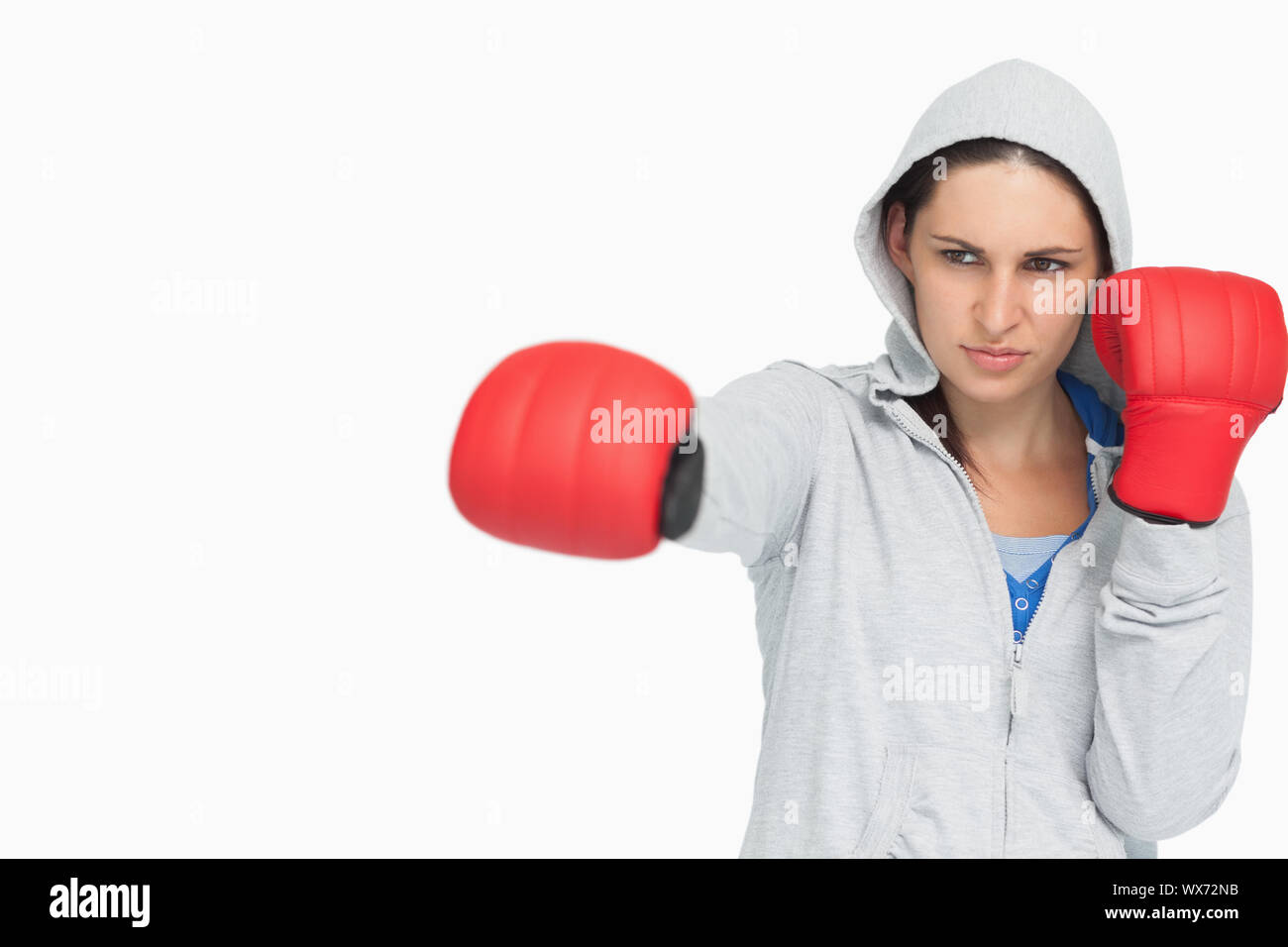 Brunette woman in sweatshirt boxing against white background Stock ...