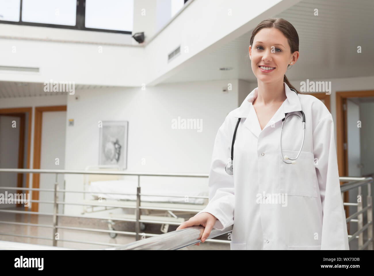 Female doctor leaning on the railing in hospital stairwell Stock Photo ...