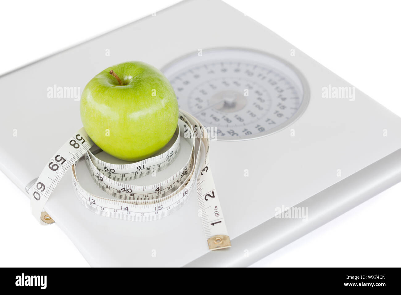 Green apple circled with a tape measure and weigh-scale against a white ...