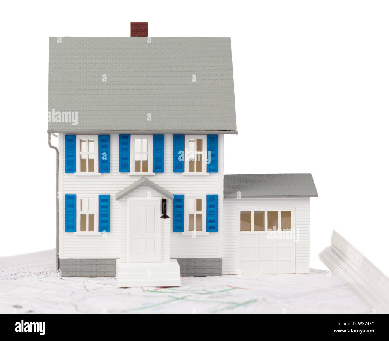 Front view of a toy house model on a ground floor plan against a white ...