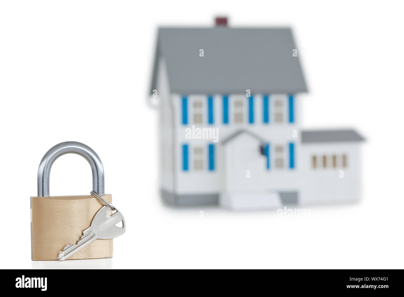 Miniature house and opened padlock against a white background Stock ...