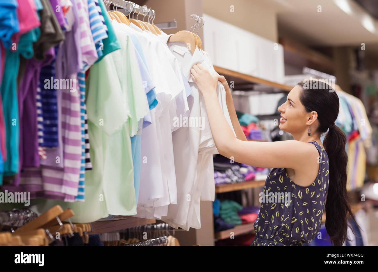Woman sorting clothes at a boutique Stock Photo - Alamy