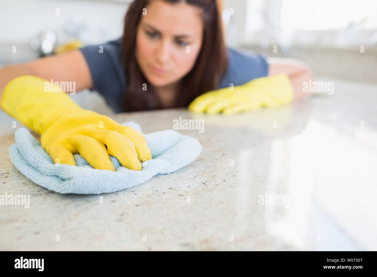 Woman wiping counter in kitchen Stock Photo - Alamy