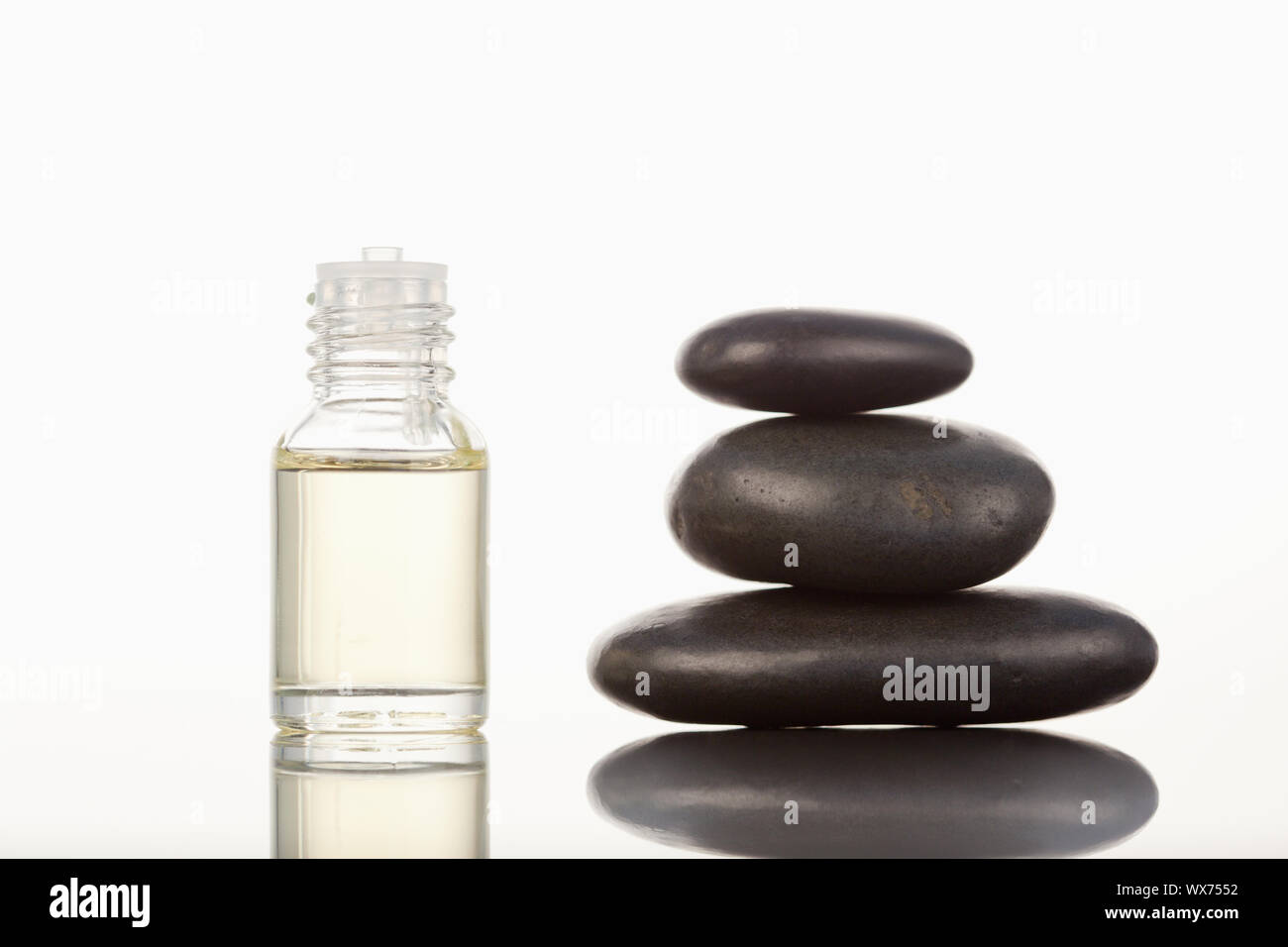 Black pebbles stack and a glass phial Stock Photo - Alamy