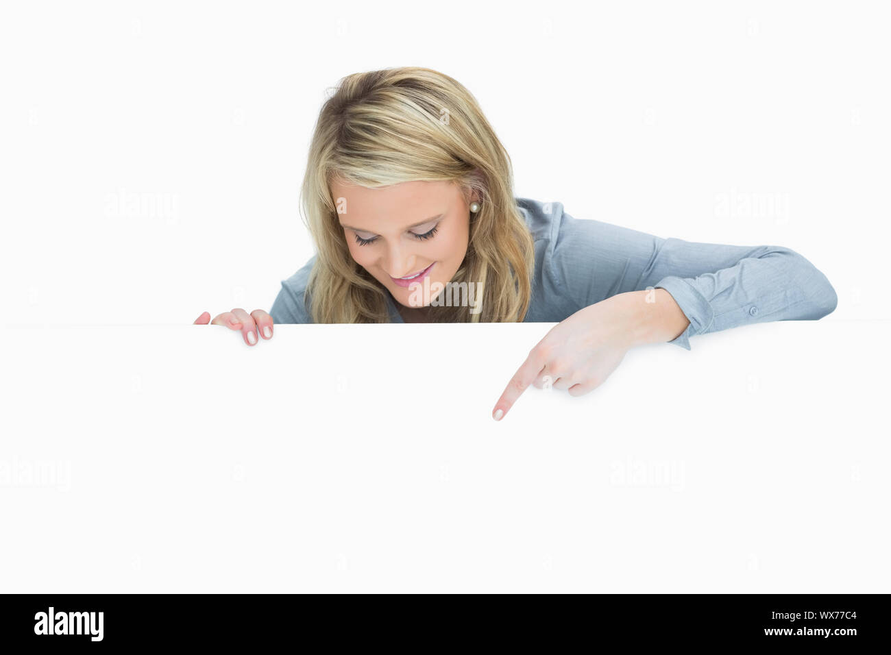 Happy woman pointing down at the poster Stock Photo - Alamy