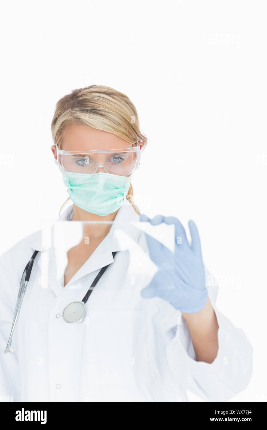 Female doctor wearing surgical gear looking at glass pane Stock Photo ...