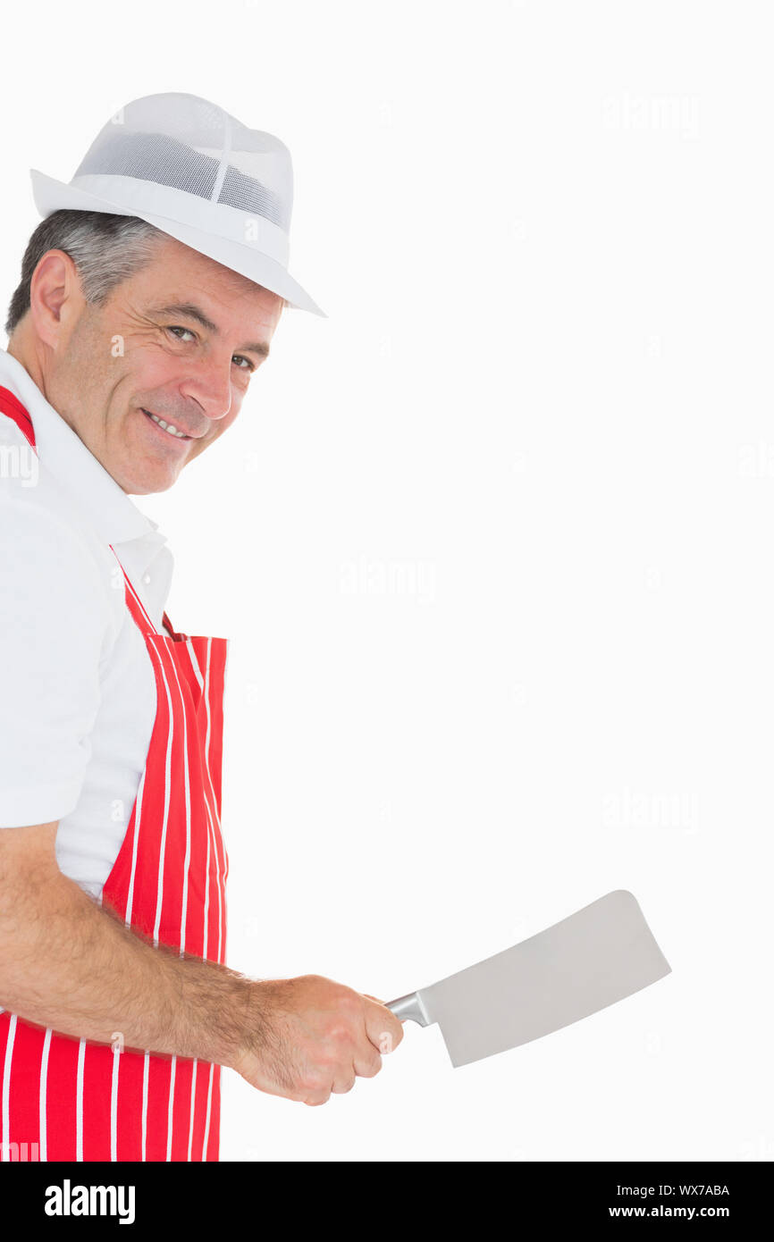 Mature butcher wielding meat cleaver and smiling Stock Photo - Alamy