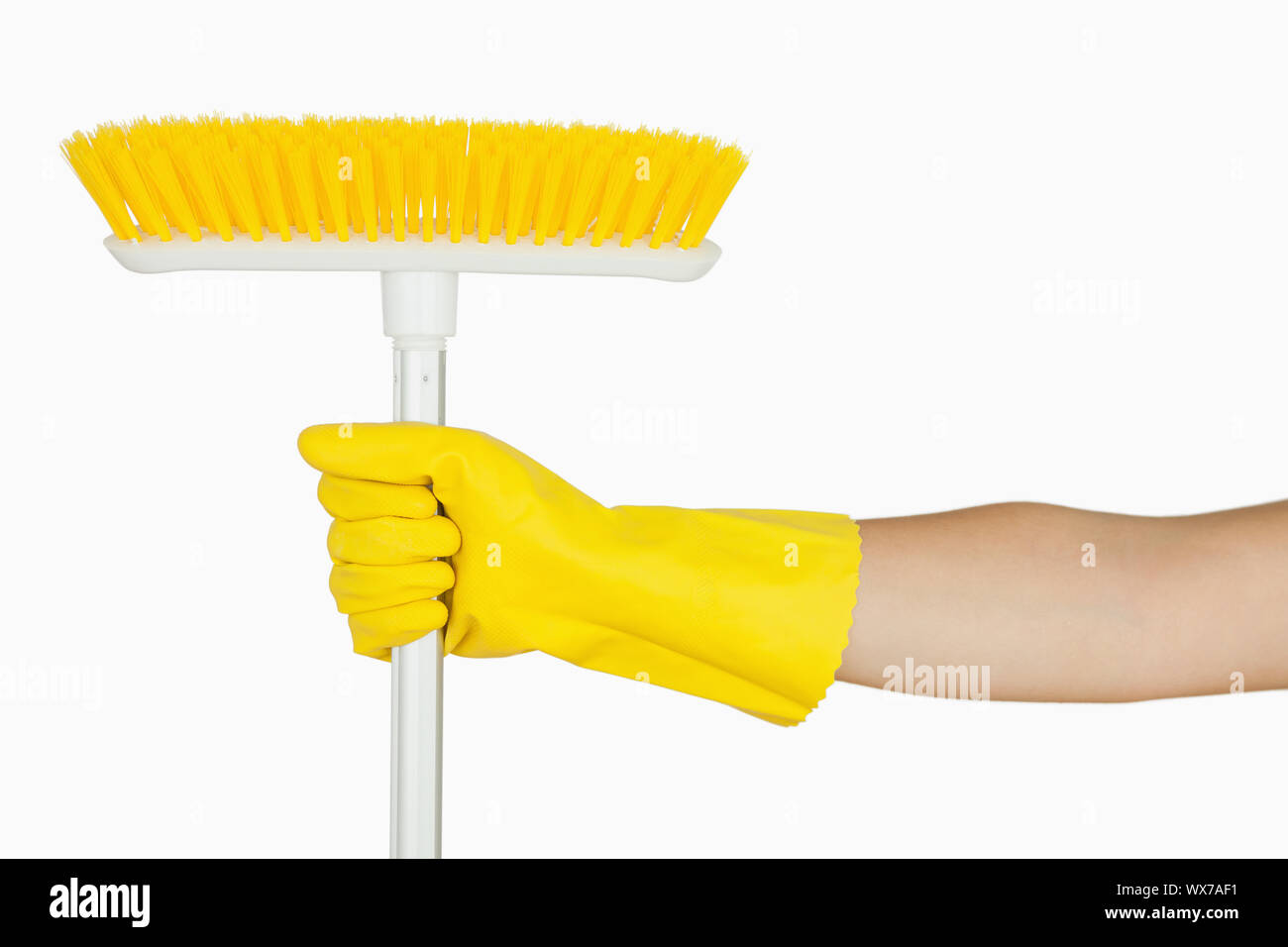 Hand in rubber glove holding sweeping brush Stock Photo - Alamy