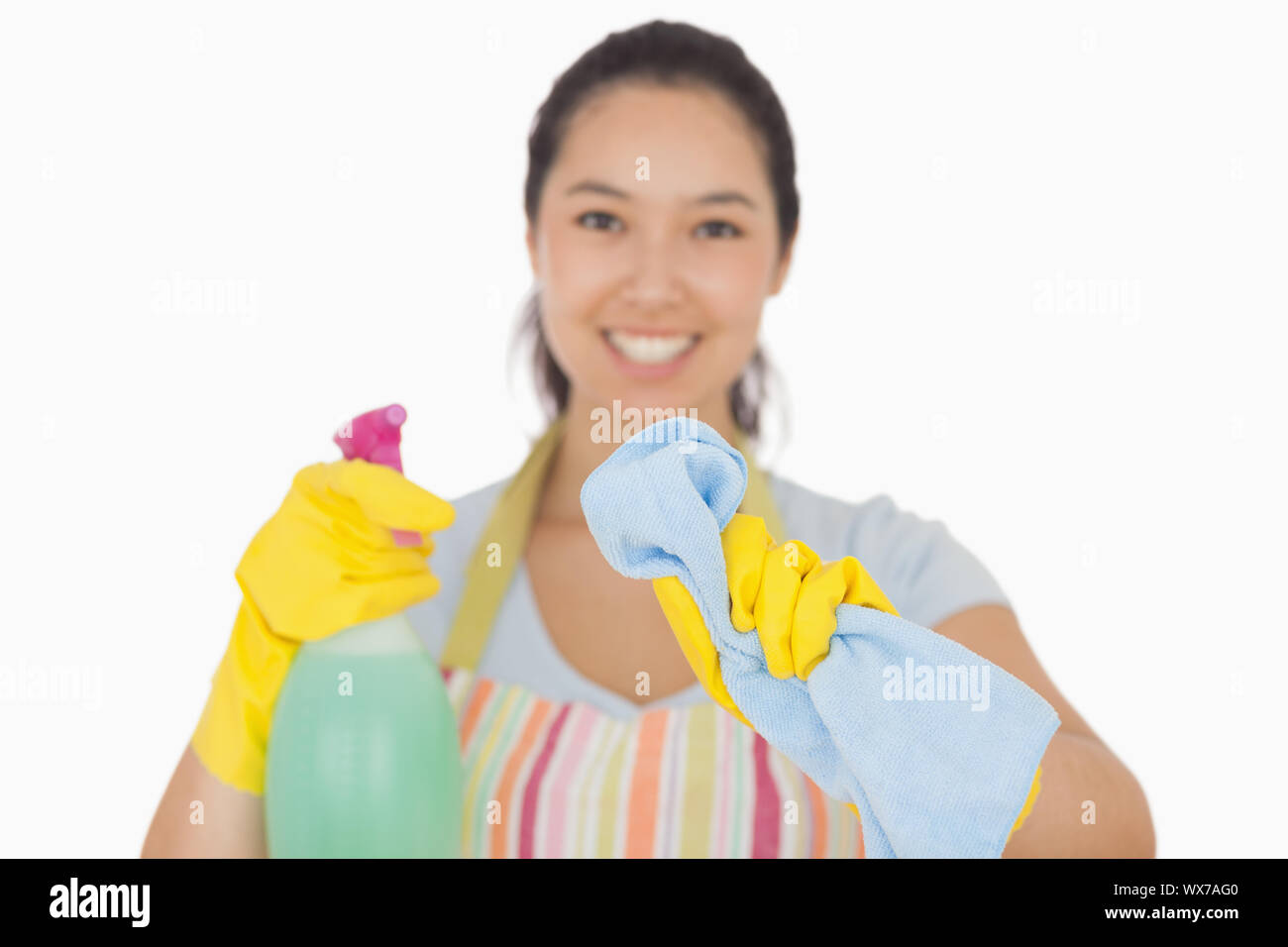 Happy woman in apron wiping with cloth in front of her Stock Photo - Alamy