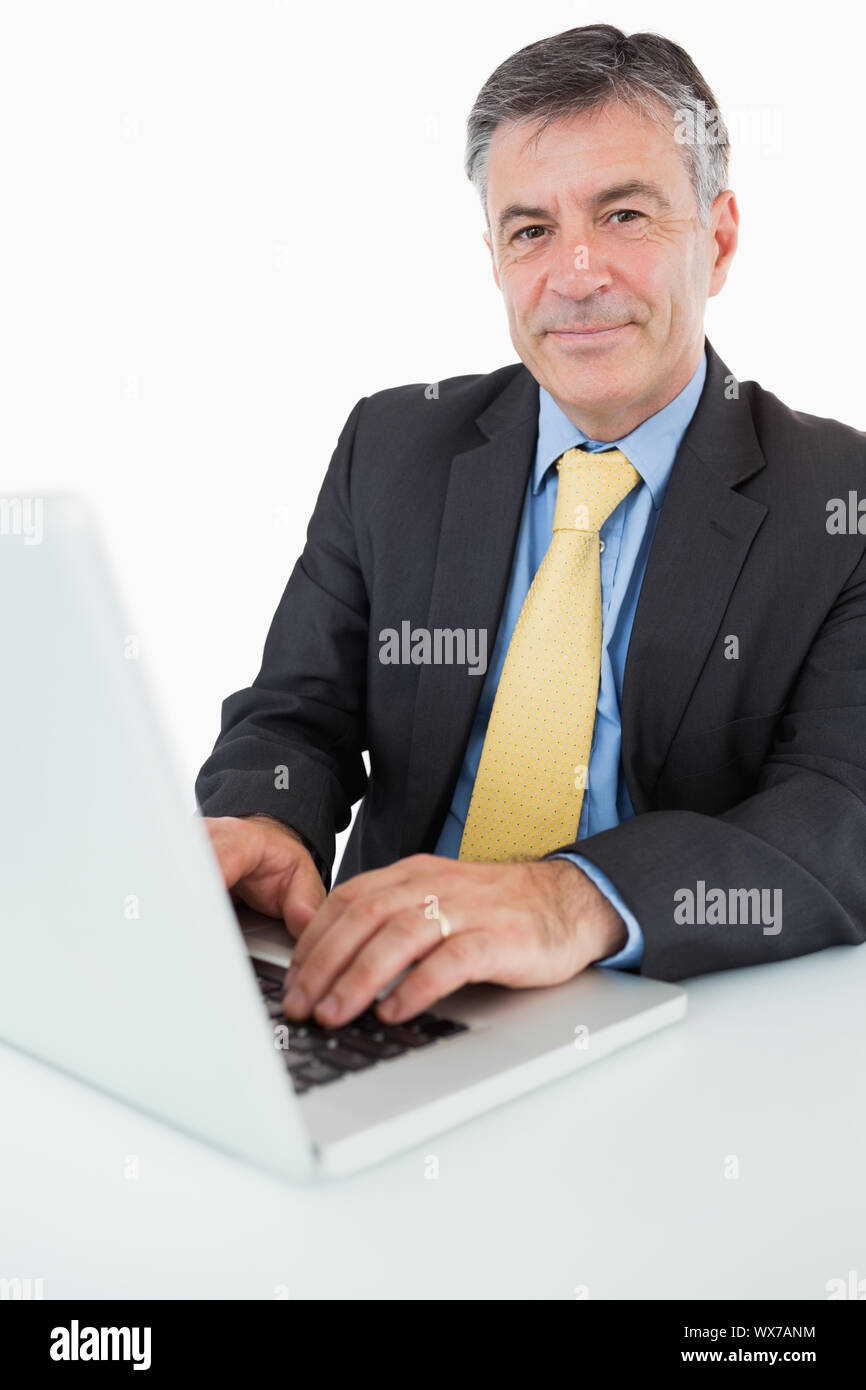 Happy man typing on his laptop at his desk Stock Photo - Alamy