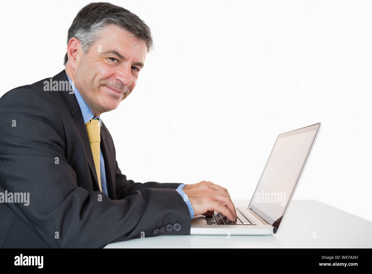 Happy man typing on his laptop on his desk in a white background Stock ...