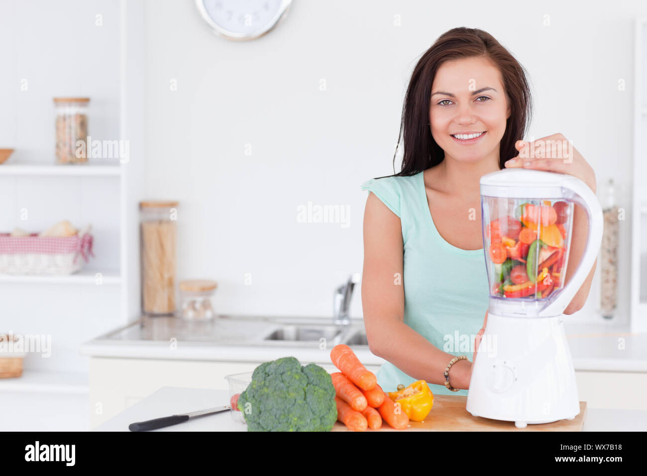 Charming woman using a blender in her kitchen Stock Photo - Alamy