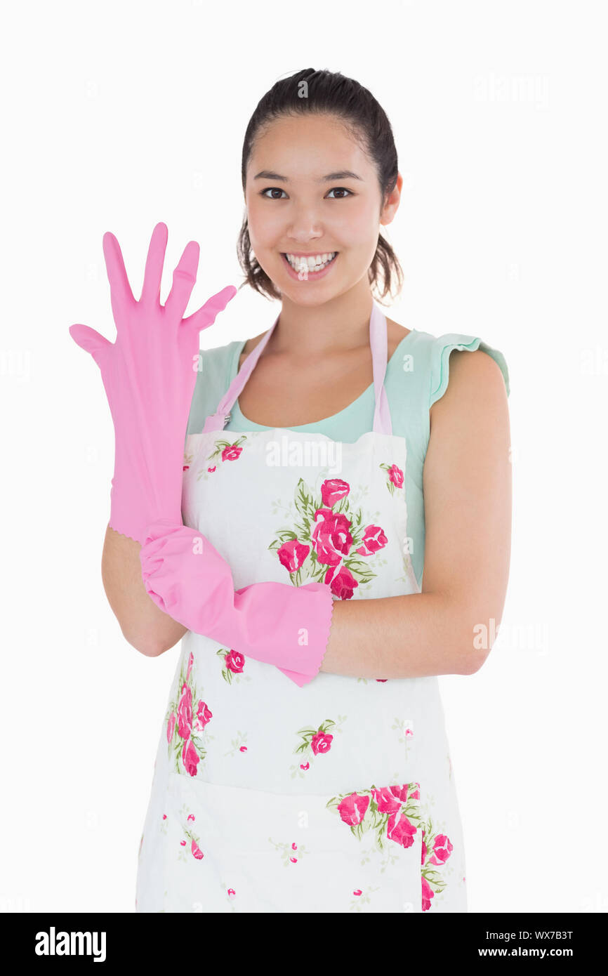Smiling woman putting on plastic gloves on a white background Stock ...