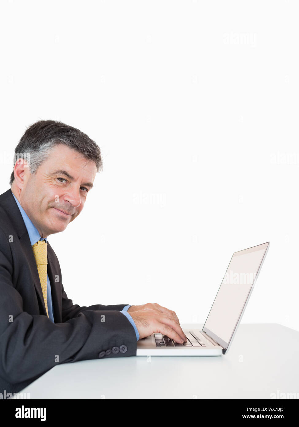 Happy man typing on his laptop on his desk in a white background Stock ...