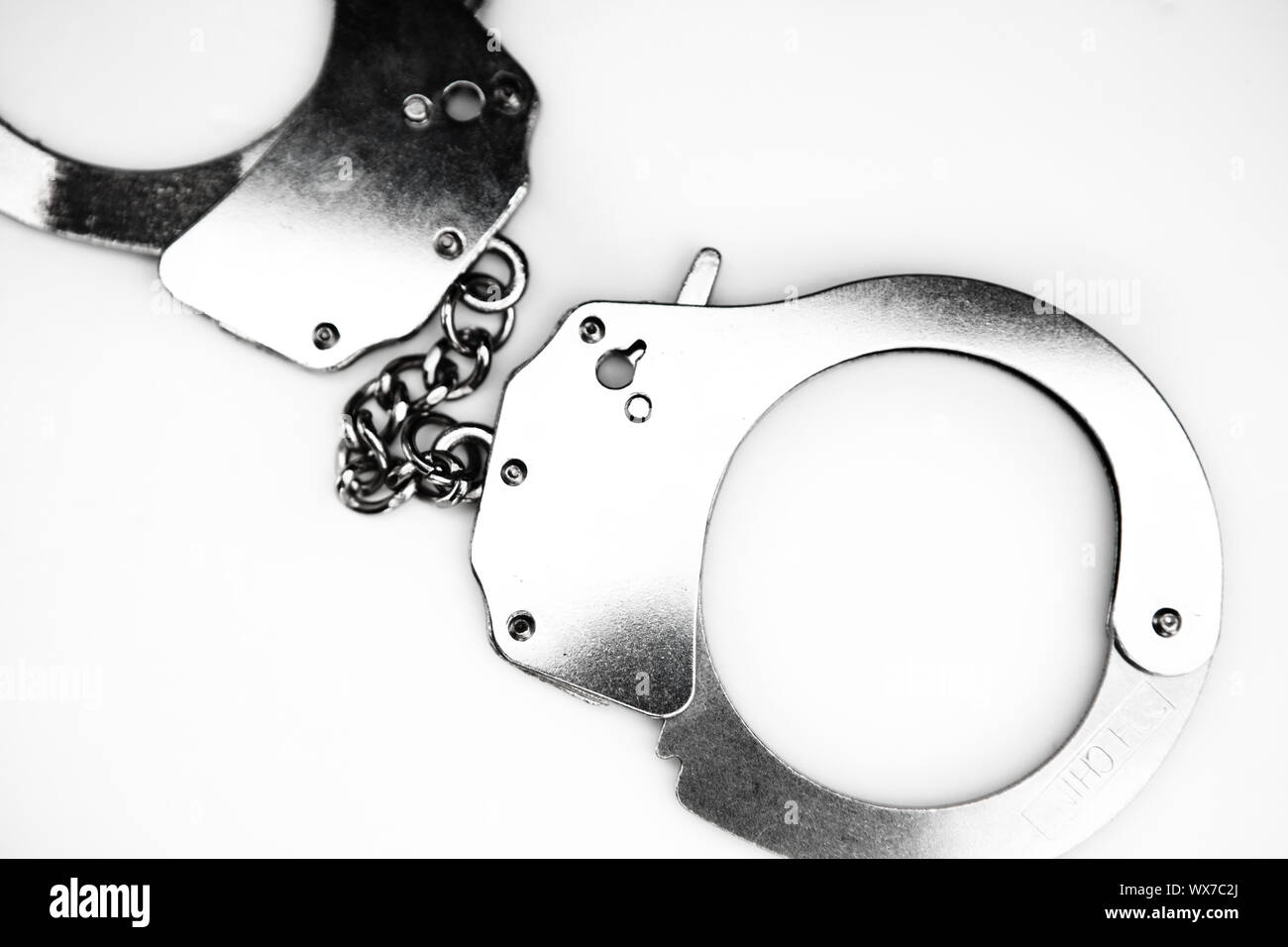 Handcuffs against white background Stock Photo - Alamy