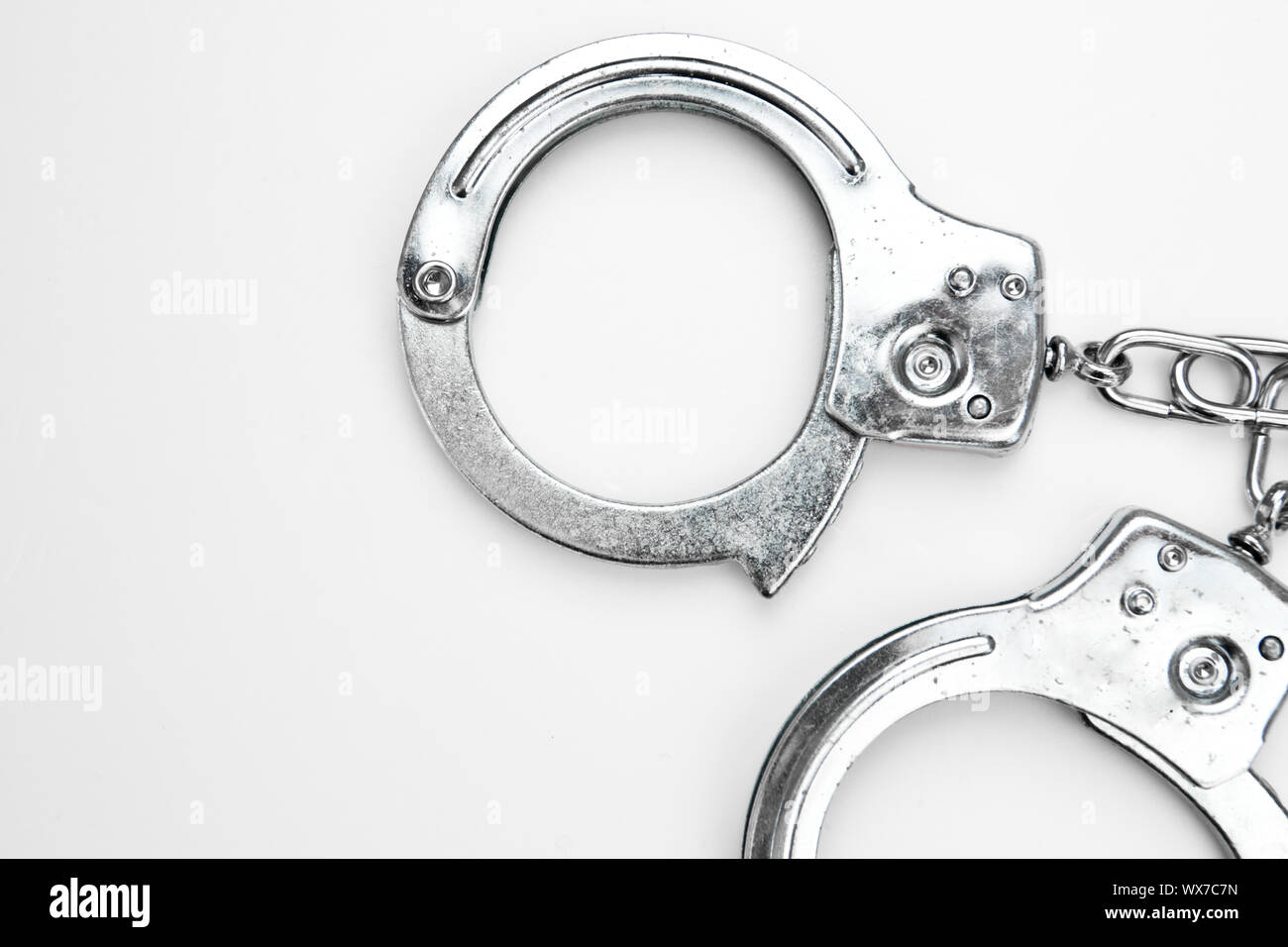 Silver manacles lying against white background Stock Photo - Alamy