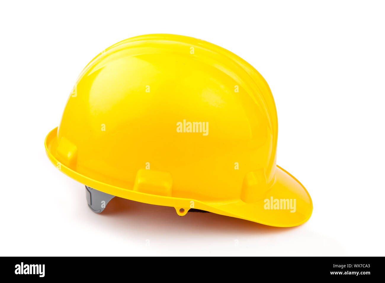 Yellow helmet lying against white background Stock Photo - Alamy