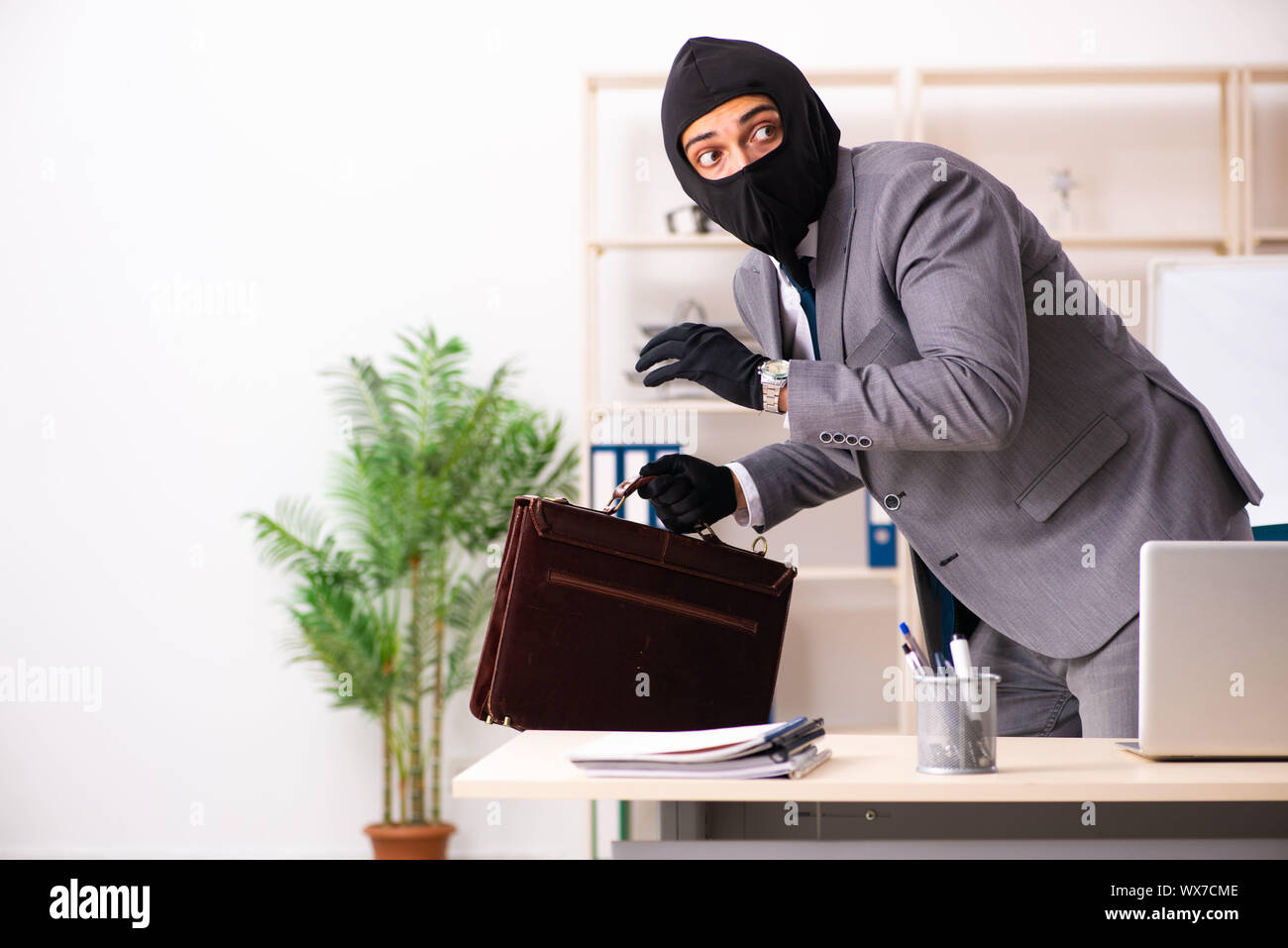 Male gangster stealing information from the office Stock Photo - Alamy