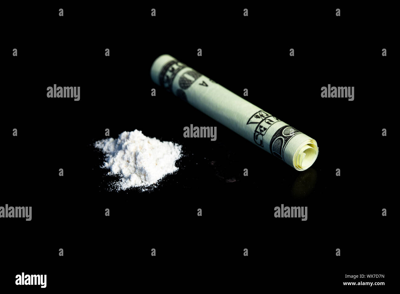 Rolled up note next to white drug substance on black background Stock ...