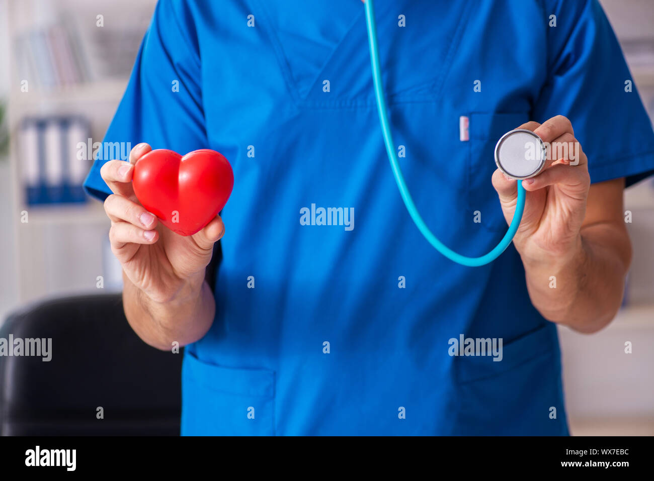 Male doctor cardiologist holding heart model Stock Photo - Alamy