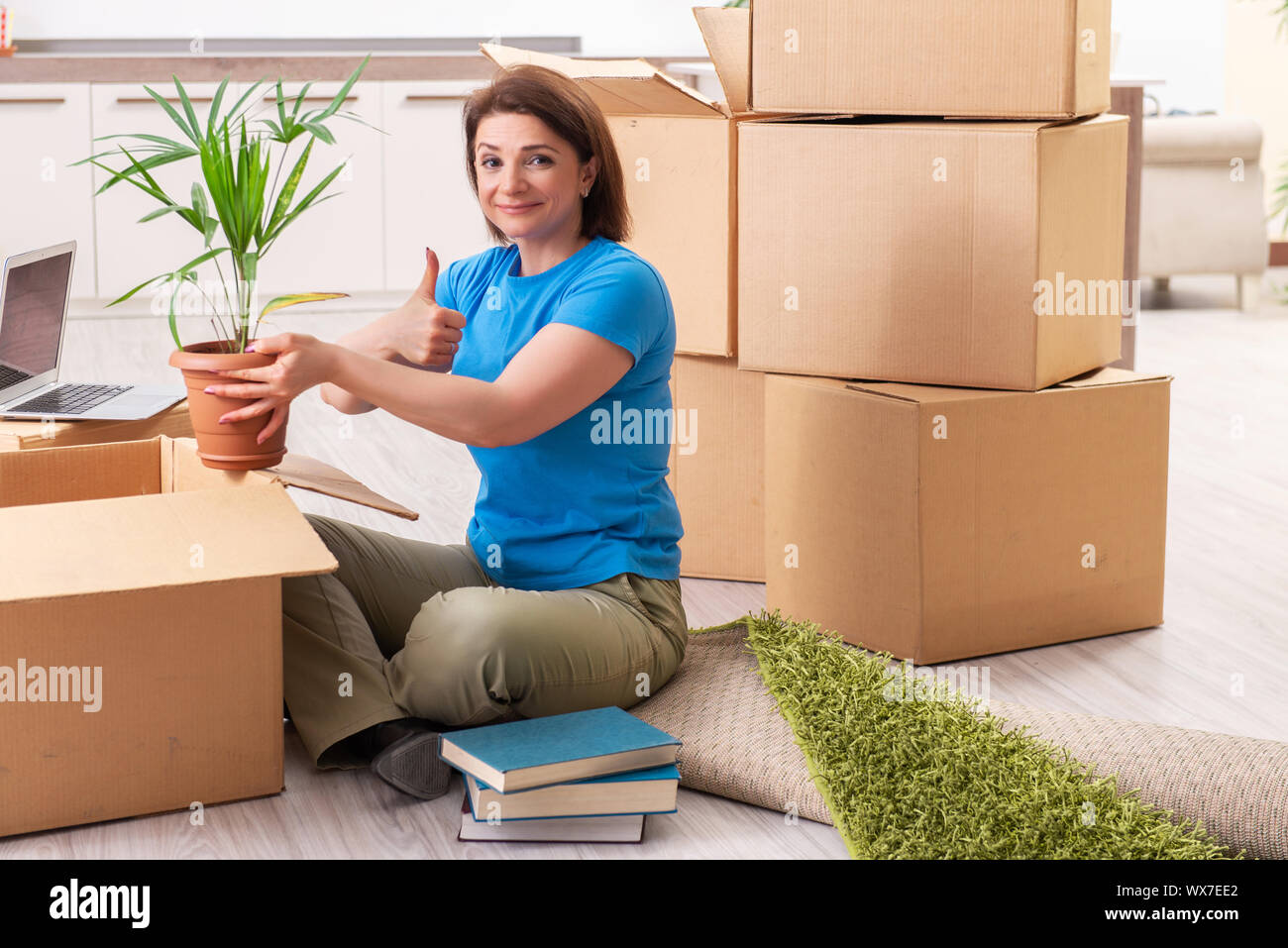 Middle-aged woman moving to new flat Stock Photo - Alamy
