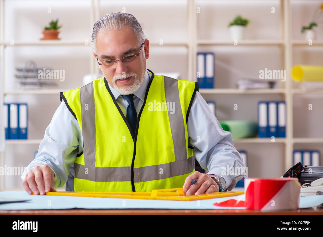 Aged construction engineer working in the office Stock Photo - Alamy