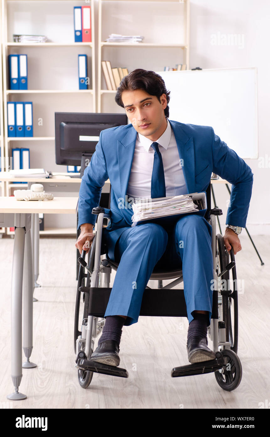 Male employee in wheelchair working at the office Stock Photo - Alamy