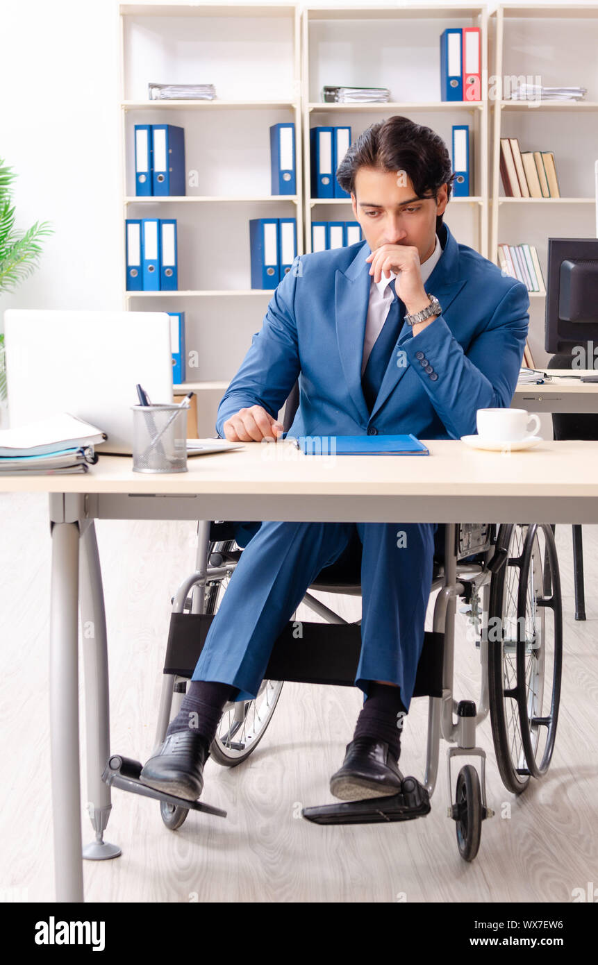 Male employee in wheelchair working at the office Stock Photo - Alamy