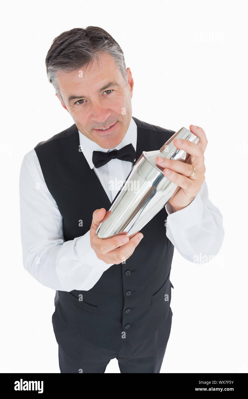 Waiter in suit shaking drink in cocktail shaker on white background ...