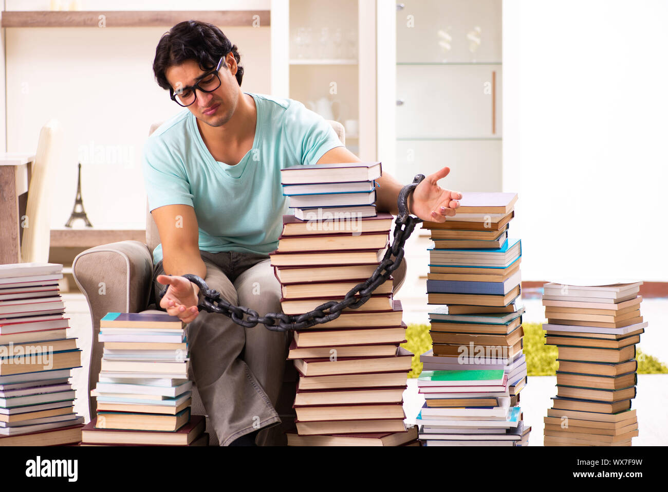 Male student with many books at home Stock Photo - Alamy