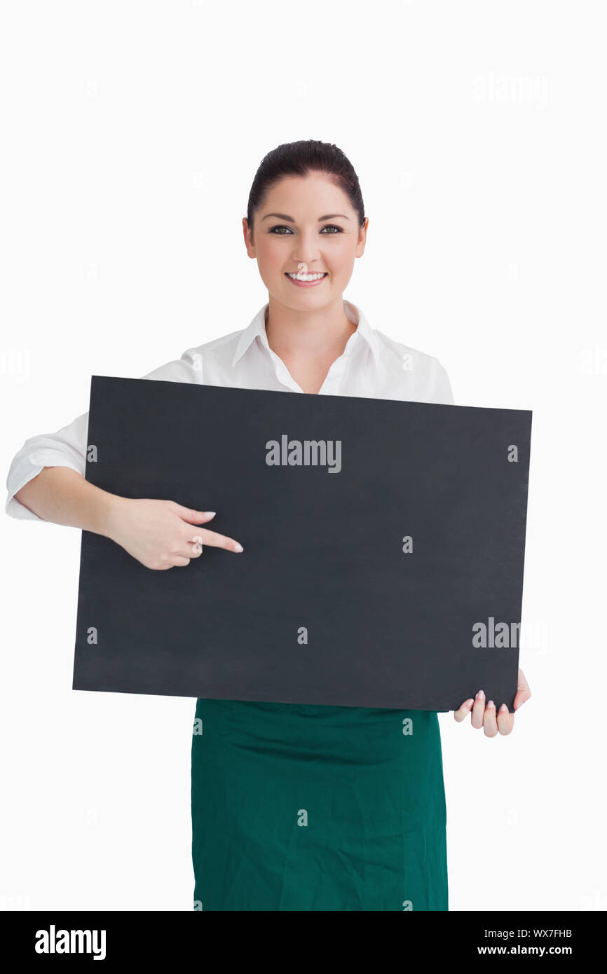 Waitress pointing to black board she is holding on white background ...