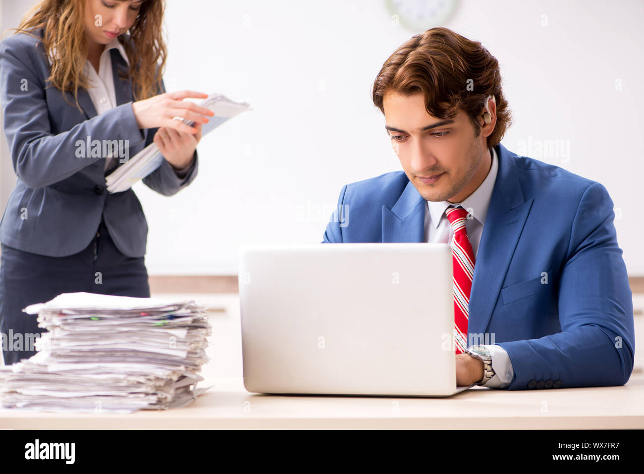 Deaf employee using hearing aid talking to boss Stock Photo - Alamy