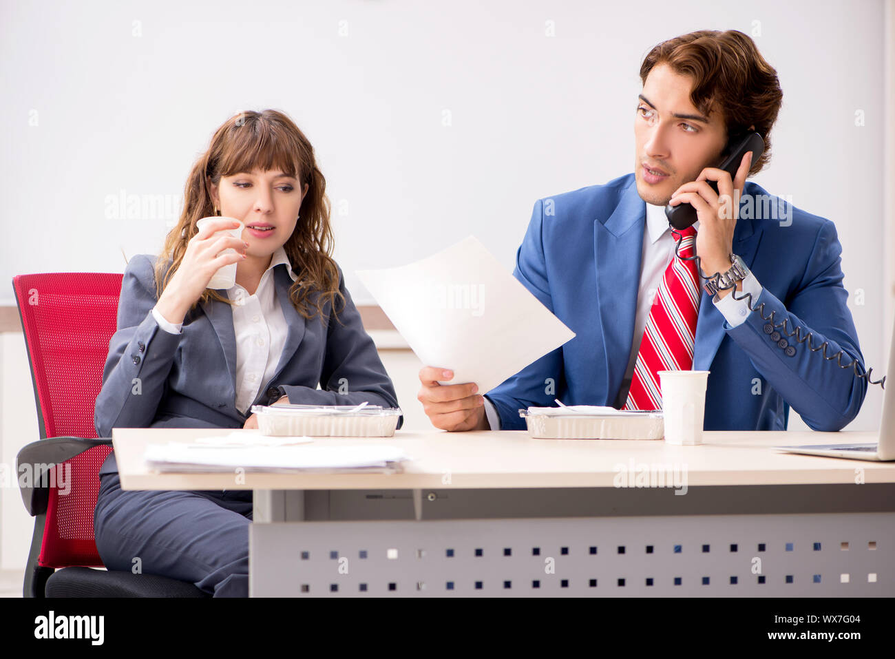 Two colleagues having lunch break at workplace Stock Photo - Alamy