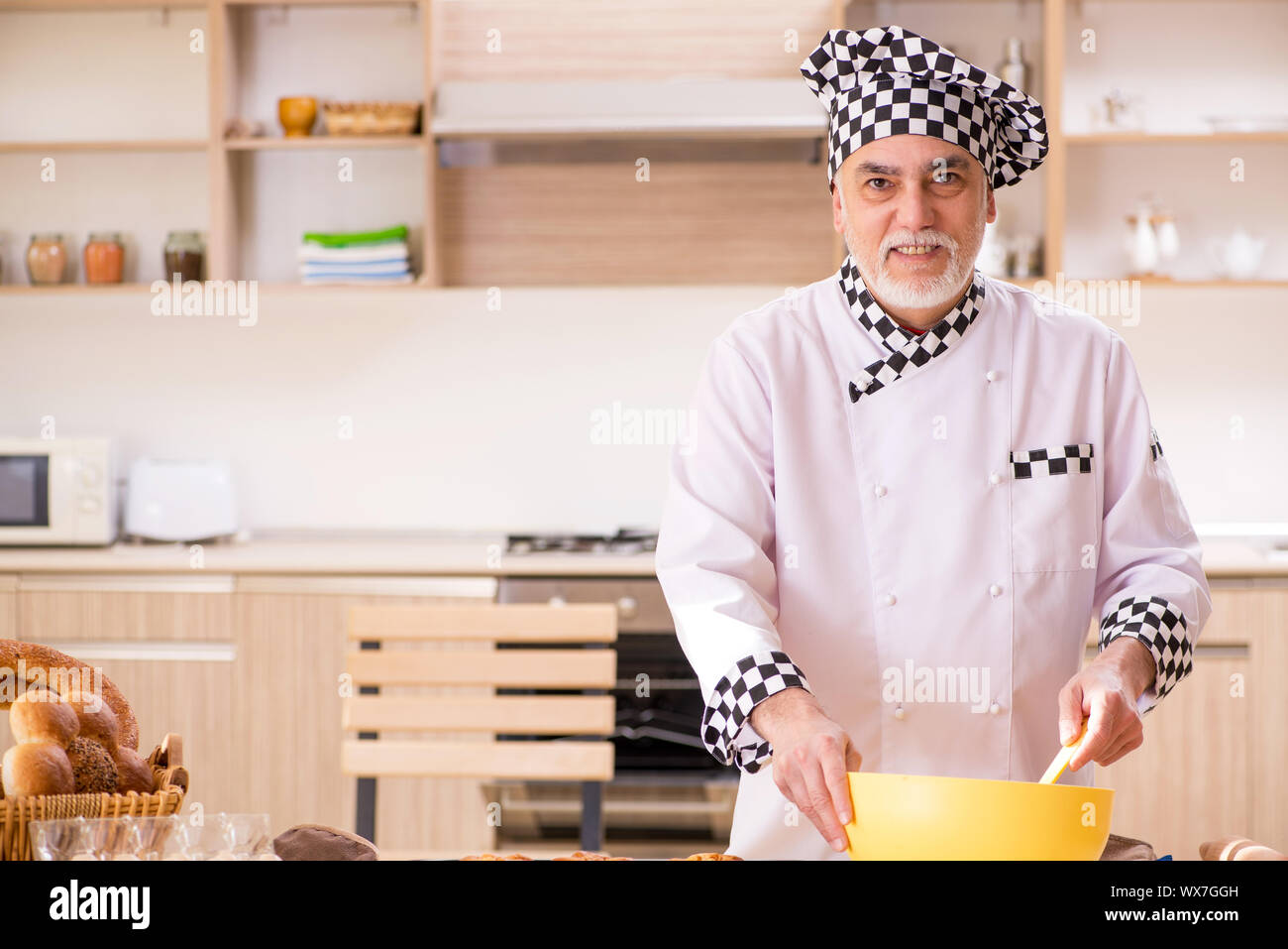 Old male baker working in the kitchen Stock Photo - Alamy