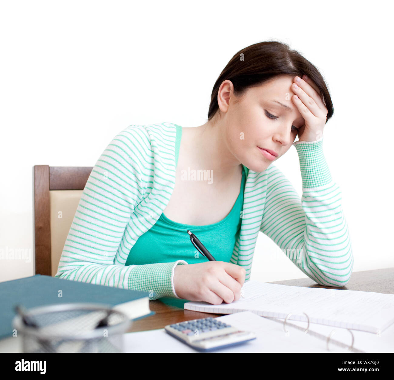 Tired student doing her homework on a desk Stock Photo - Alamy