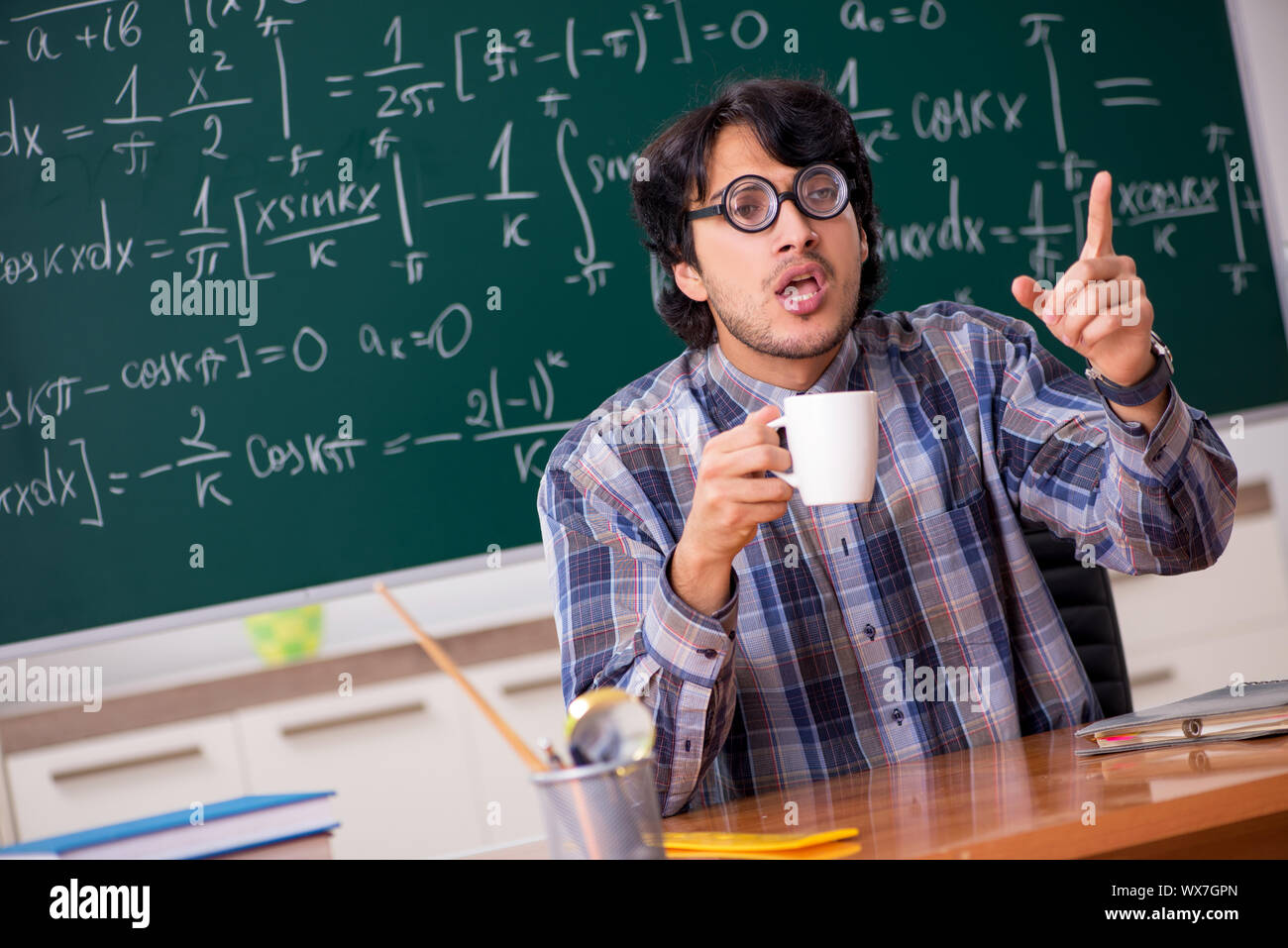Funny male math teacher in the classroom Stock Photo - Alamy