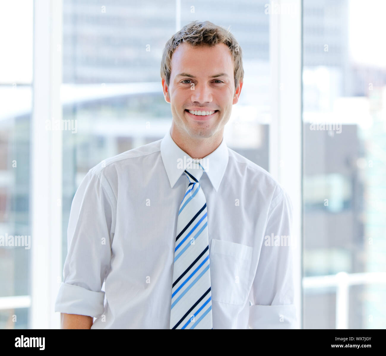 Portrait of a smiling businessman standing in a modern building Stock ...