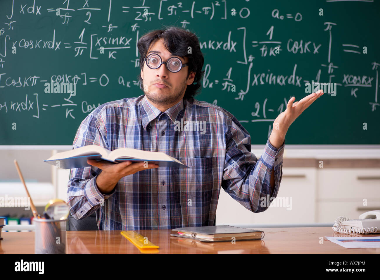 Funny male math teacher in the classroom Stock Photo - Alamy
