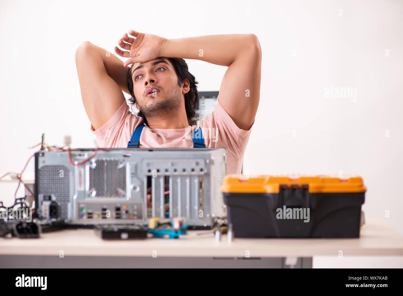 Young male contractor repairing computer Stock Photo - Alamy