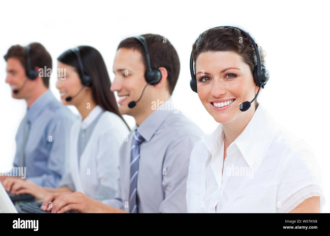 Positive customer service agents working in a call center against a ...
