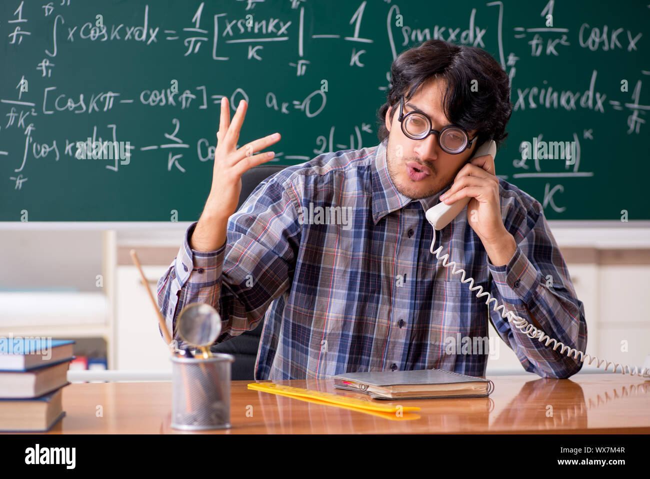 Funny male math teacher in the classroom Stock Photo - Alamy