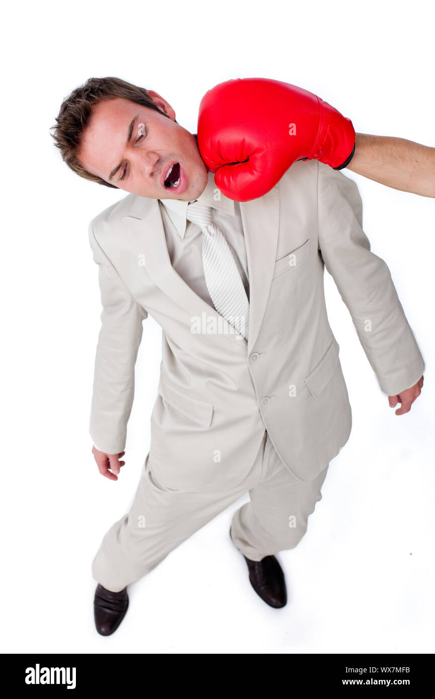 Young businessman being hit with a boxing glove isolated on a white ...