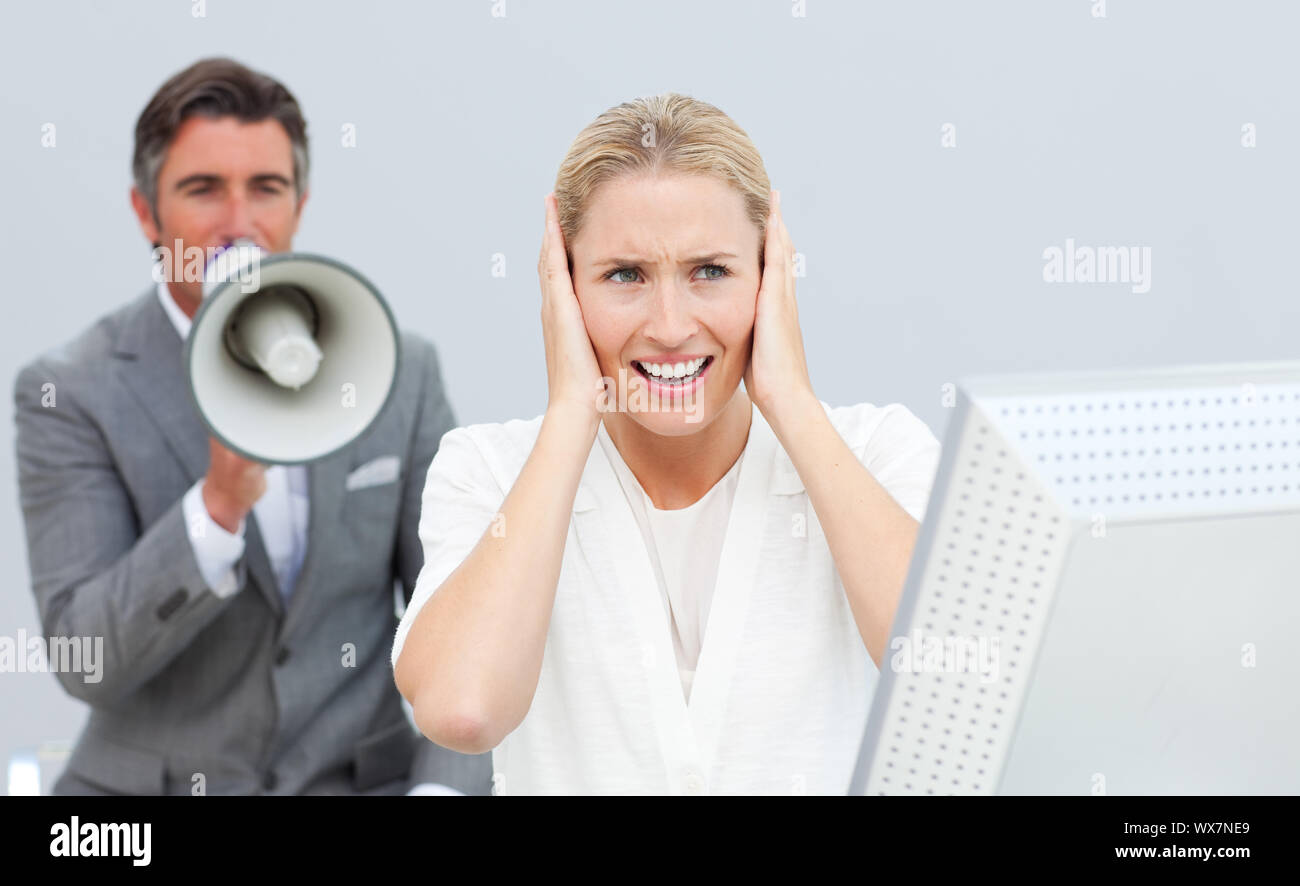 Competitive manager yelling through a megaphone in his colleague's ears ...