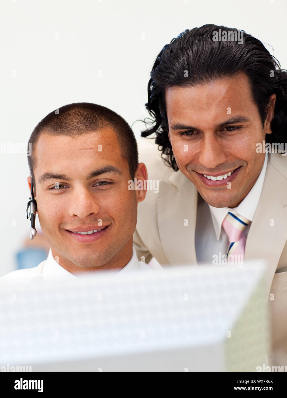 Two colleagues looking at a computer in the office Stock Photo - Alamy